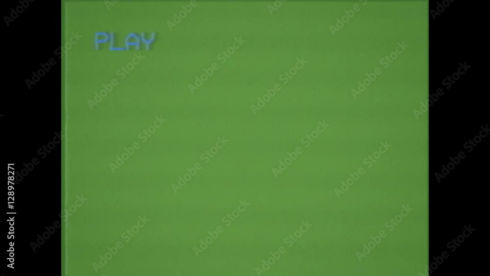 An old damaged VHS tape playing, green screen with PLAY text. A vintage ...