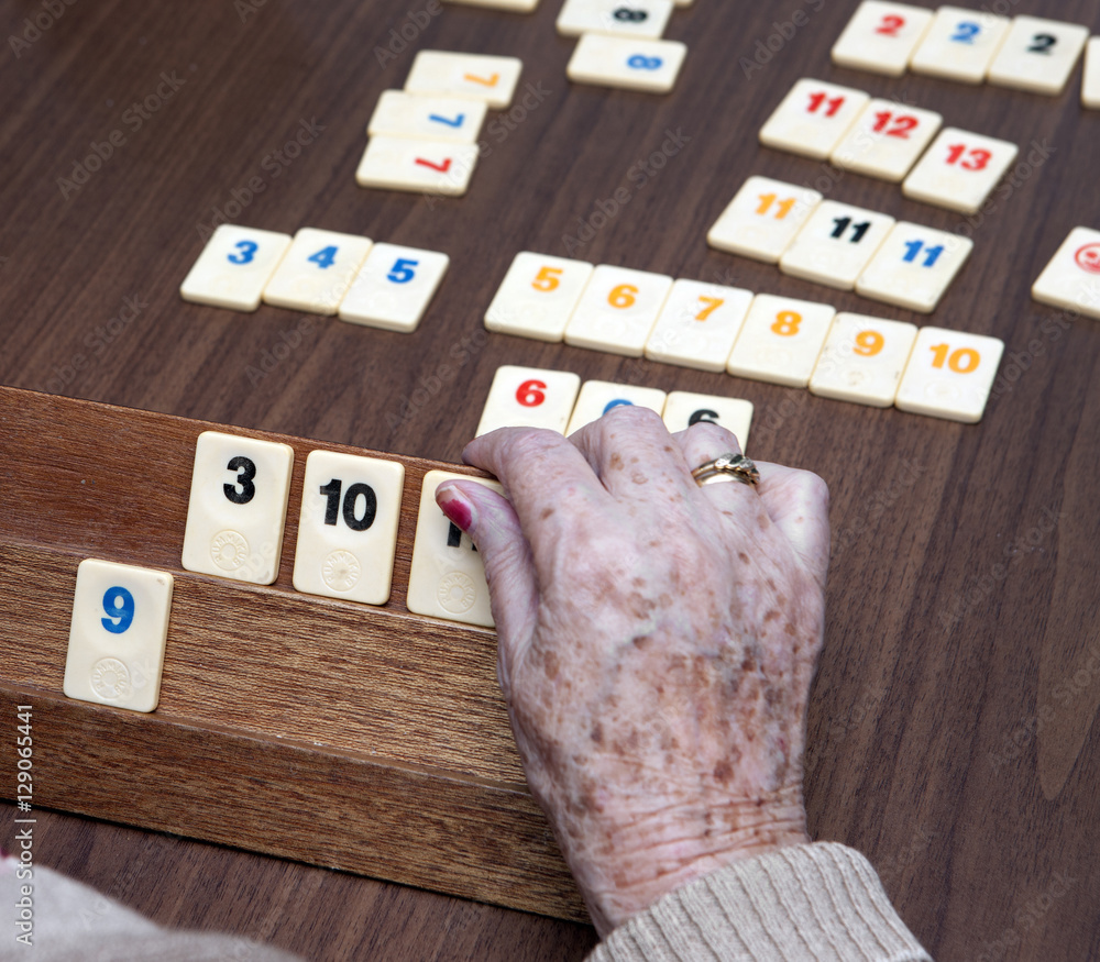 Playing rummikub. Hand of old woman playing a game. Retired. Elderly ...