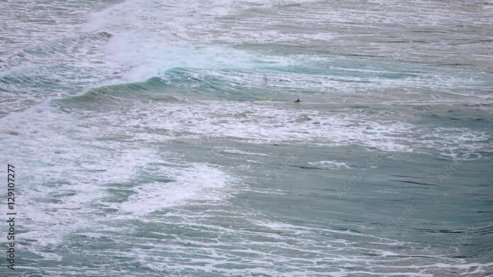 A lone swimmer struggling large sea waves. Dramatic aerial seascape ...