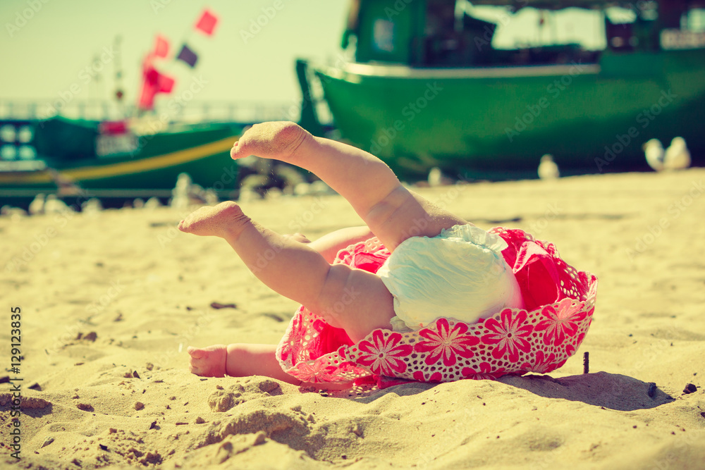 Small child fell over on the sand. Stock Photo | Adobe Stock