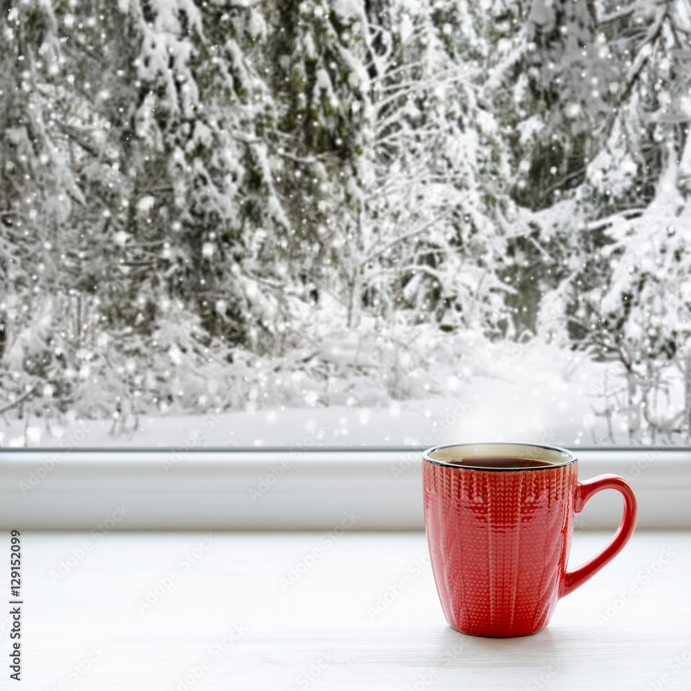 Coffee cup on a window sill. In the background, a beautiful winter ...