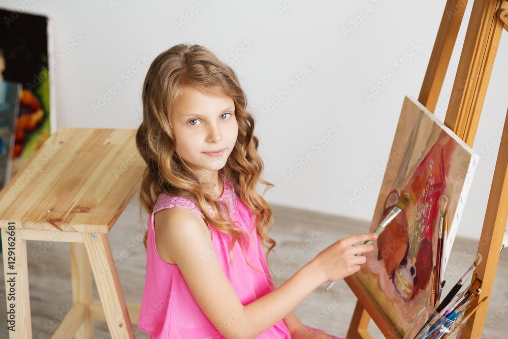 Portrait of a lovely little girl painting a picture in a studio Stock ...