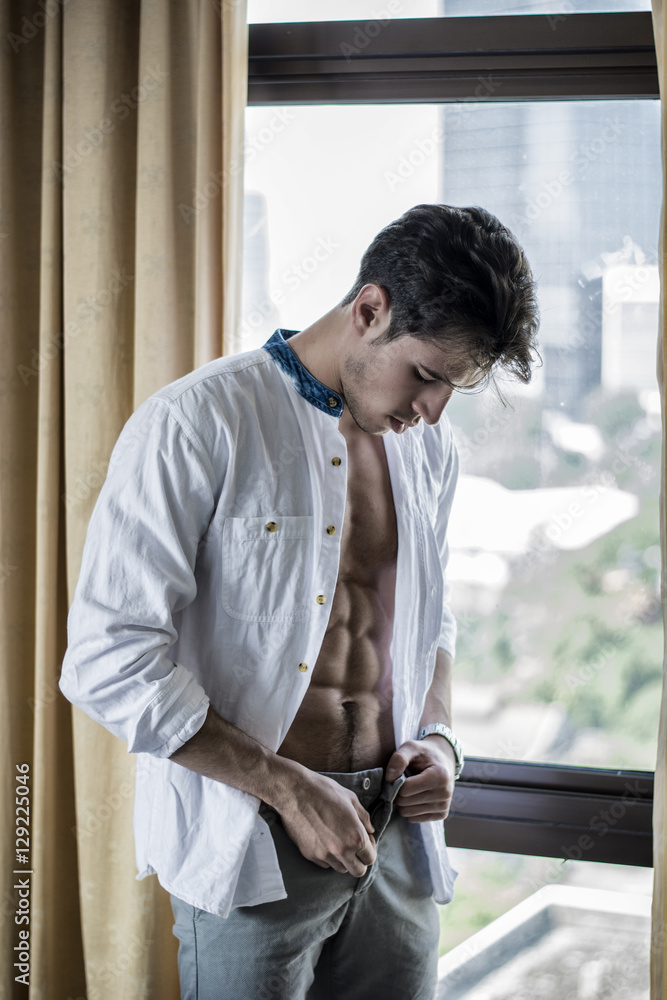 Sexy young man standing with shirt open on muscular chest in his ...