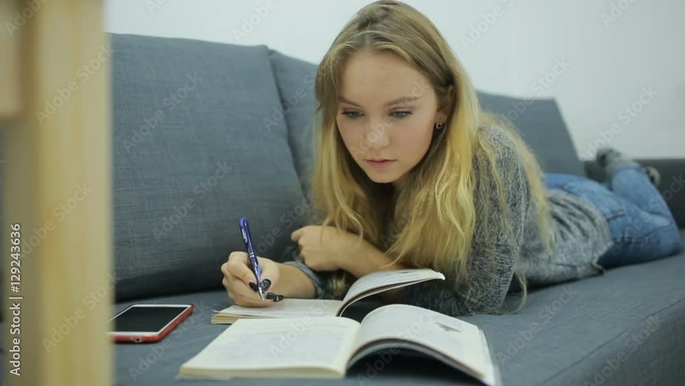 young girl student doing homework at home on the couch Stock Video ...