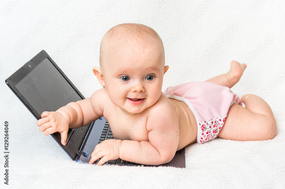 Cute baby girl in a diaper playing with laptop Stock Photo | Adobe Stock