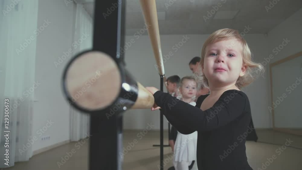 Sad girl about ballet bar. Cute little girl with sad eyes crying in the ...