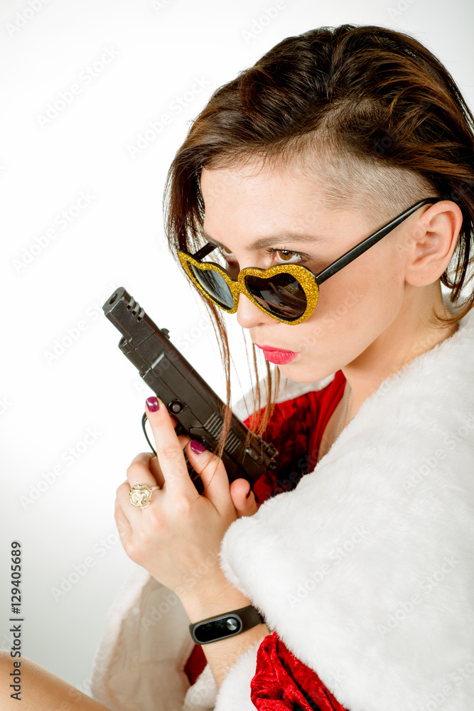 Dangerous bad Santa woman holding gun with evil smile looking at camera ...