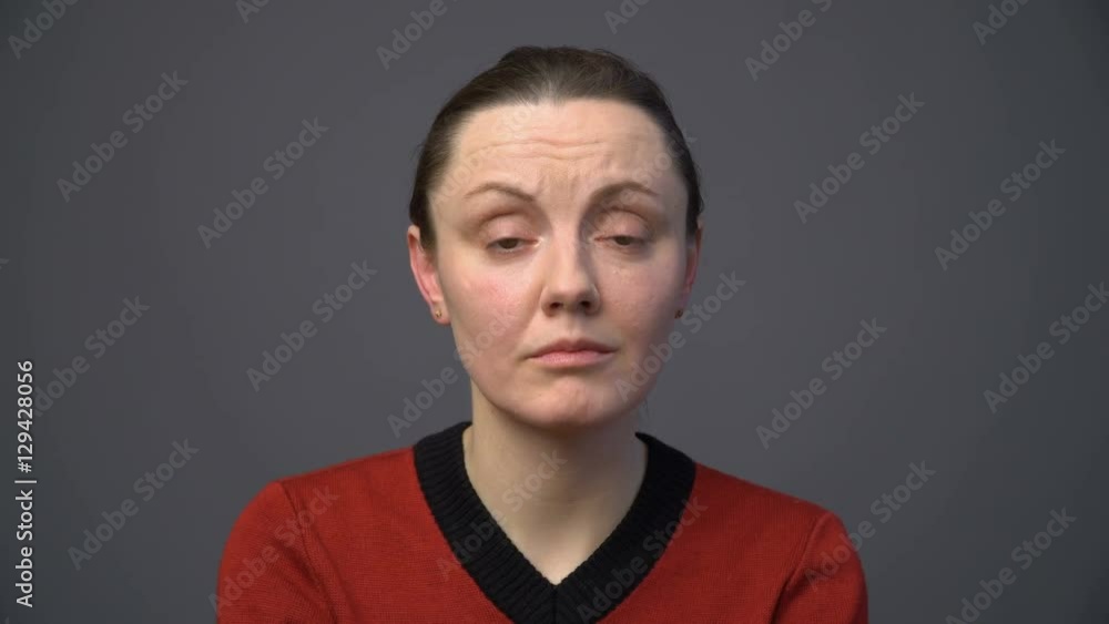 Gloomy face of a sad woman looking down, zoom in, gray background Stock ...