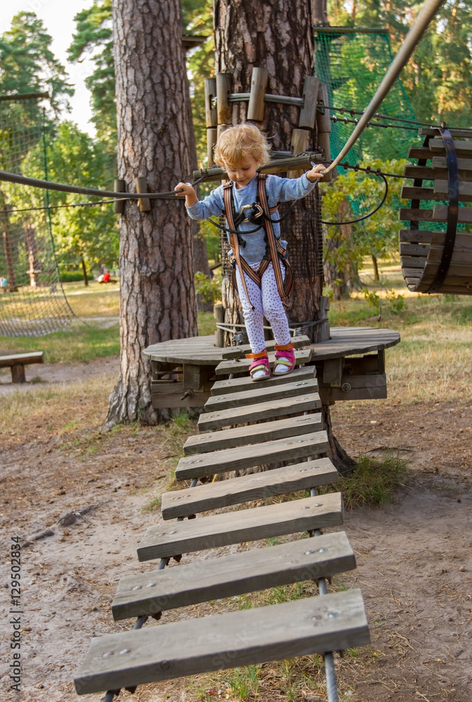 Little girl overcomes obstacles. / Three-year girl the blonde with a ...