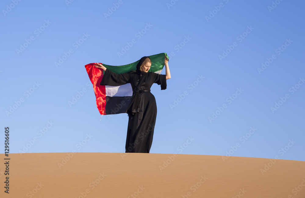 Foto de Woman in traditional Emirati dress (abaya) with United Arab ...