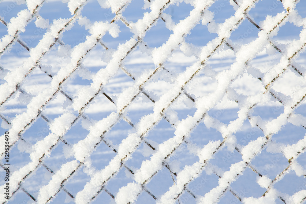 Snow on the frosty steel fence in winter after blizzard. Background ...
