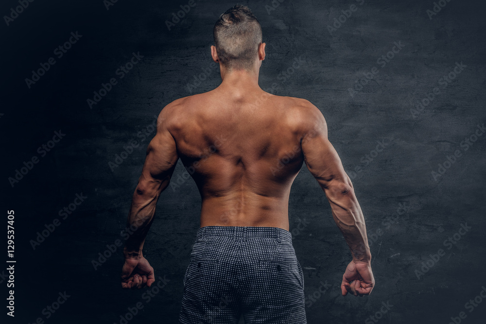 Man's muscular back on grey vignette background. Stock-Foto | Adobe Stock