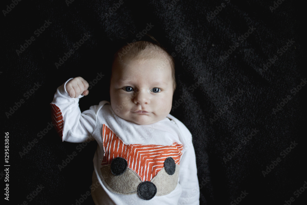 Portrait of baby flexing muscles Photos | Adobe Stock