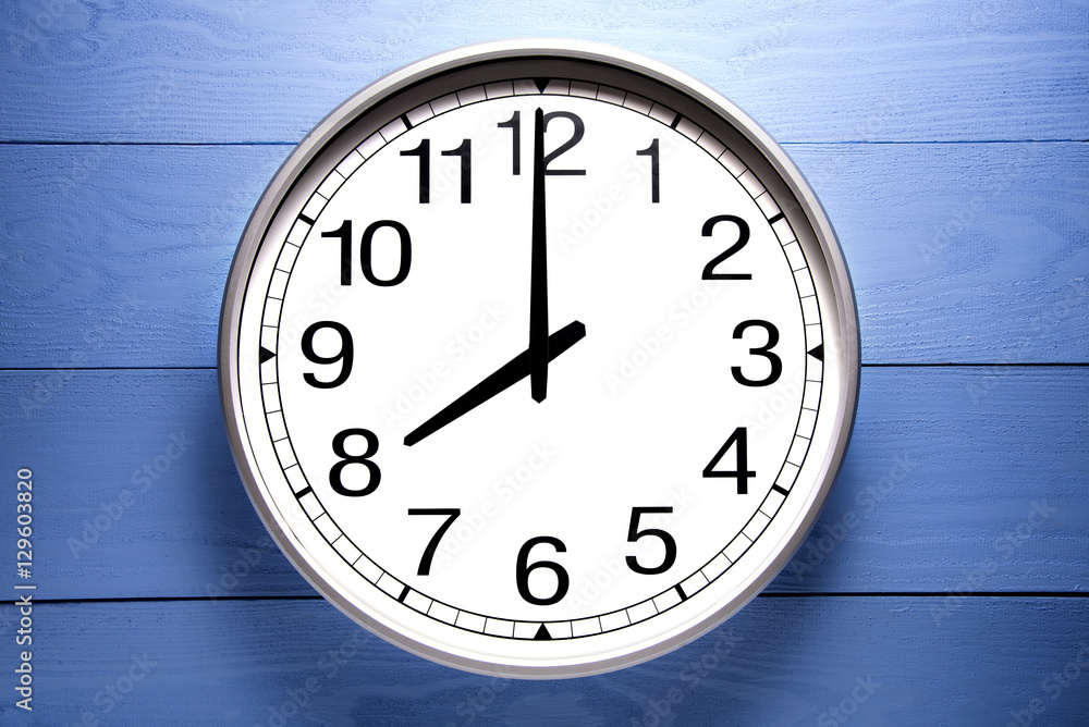 Round clock shows shows at 8 o'clock, clock on blue background Photos ...