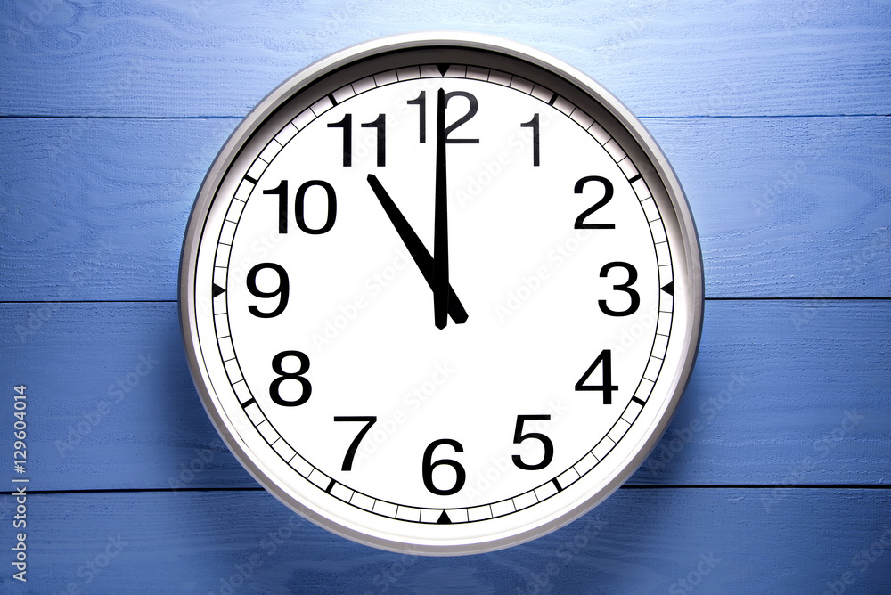 Round clock shows shows at 11 o'clock, clock on blue background Stock ...