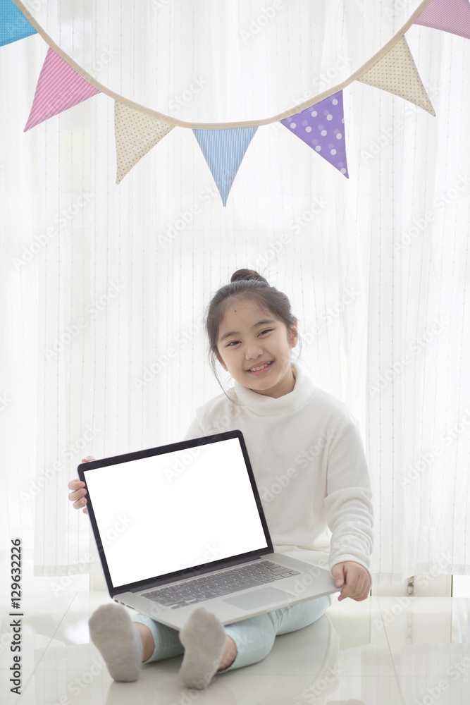 Happy Asian girl showing laptop screen in decorated room with pastel ...