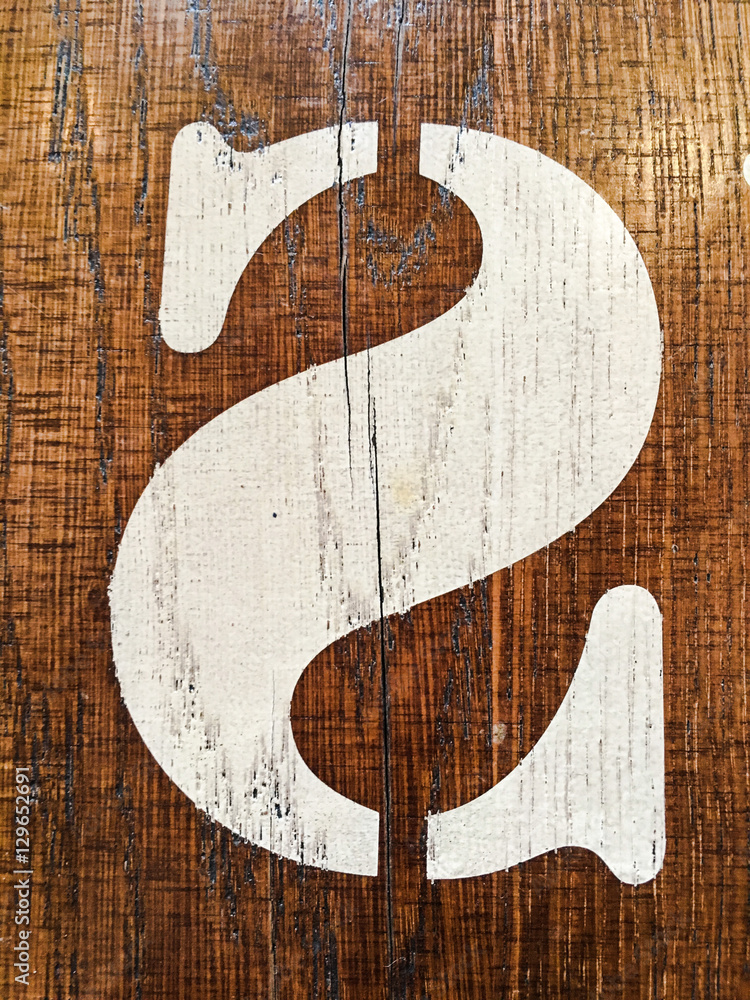 Wooden alphabet letter S, mirrored back. Written letter with paint on a ...