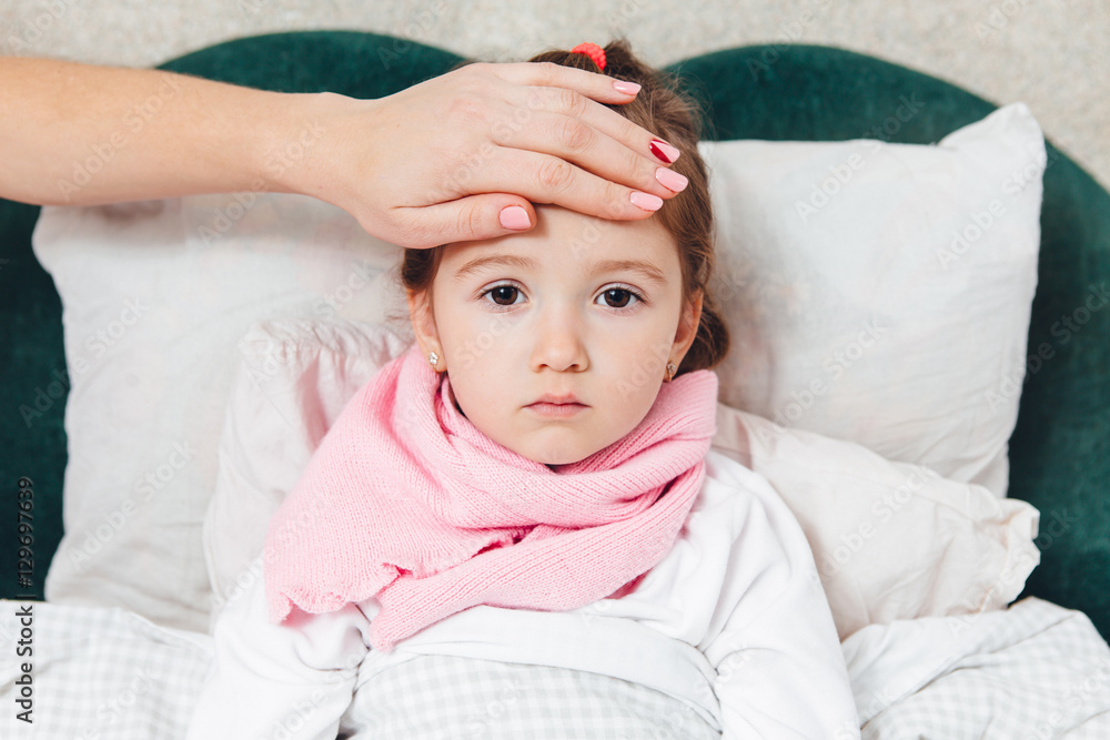 Sick child lying in the bed and touch her forehaed Stock Photo | Adobe ...
