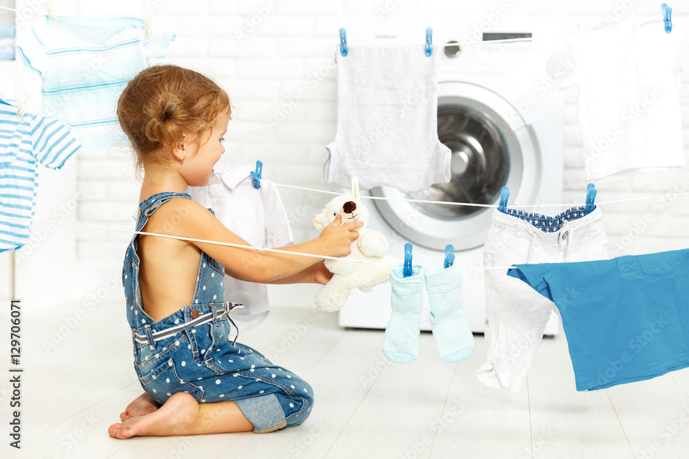 child fun happy little girl to wash clothes and teddy bear in l Stock ...