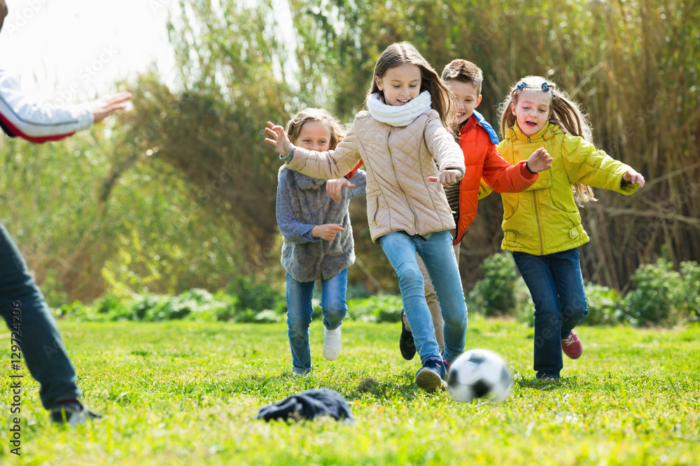 Happy kids playing football outdoors Stock Photo | Adobe Stock
