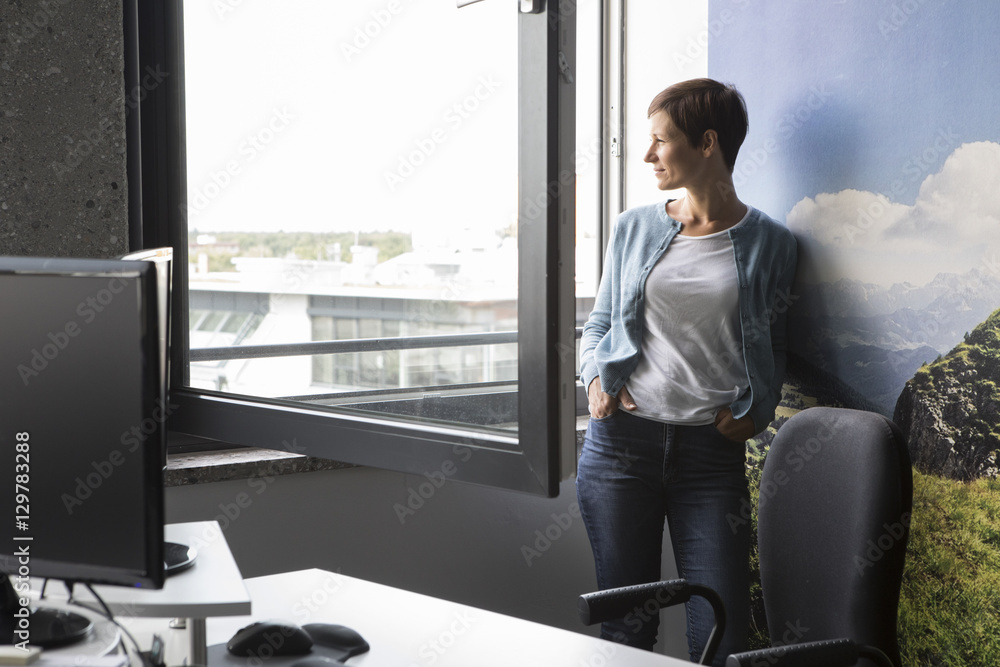 Woman in office looking out of window Stock-Foto | Adobe Stock
