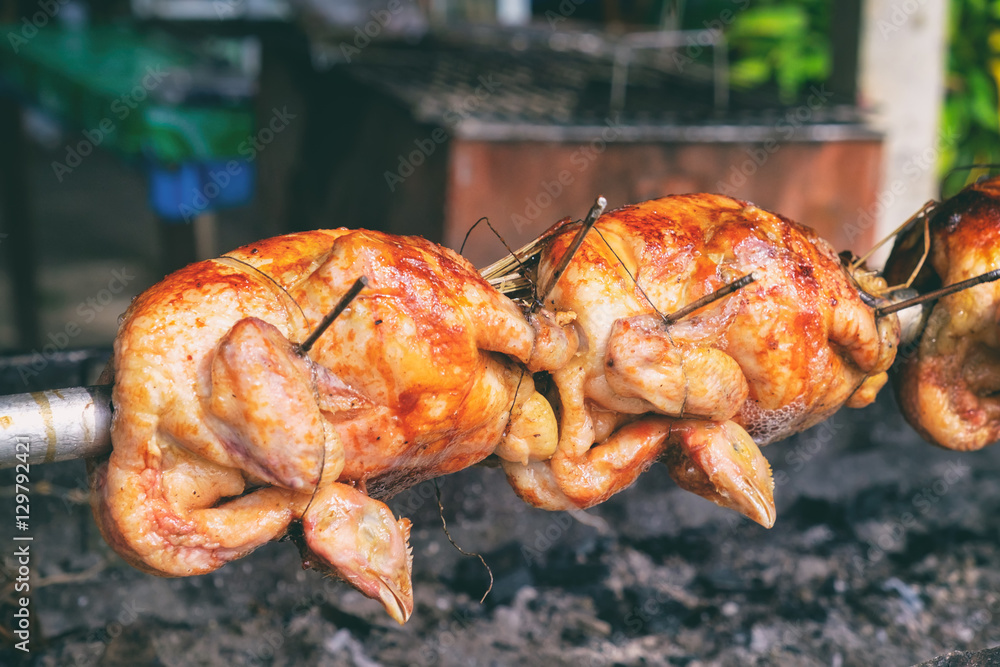 Free range chicken fire roasting traditional way on skewer at Thai old ...