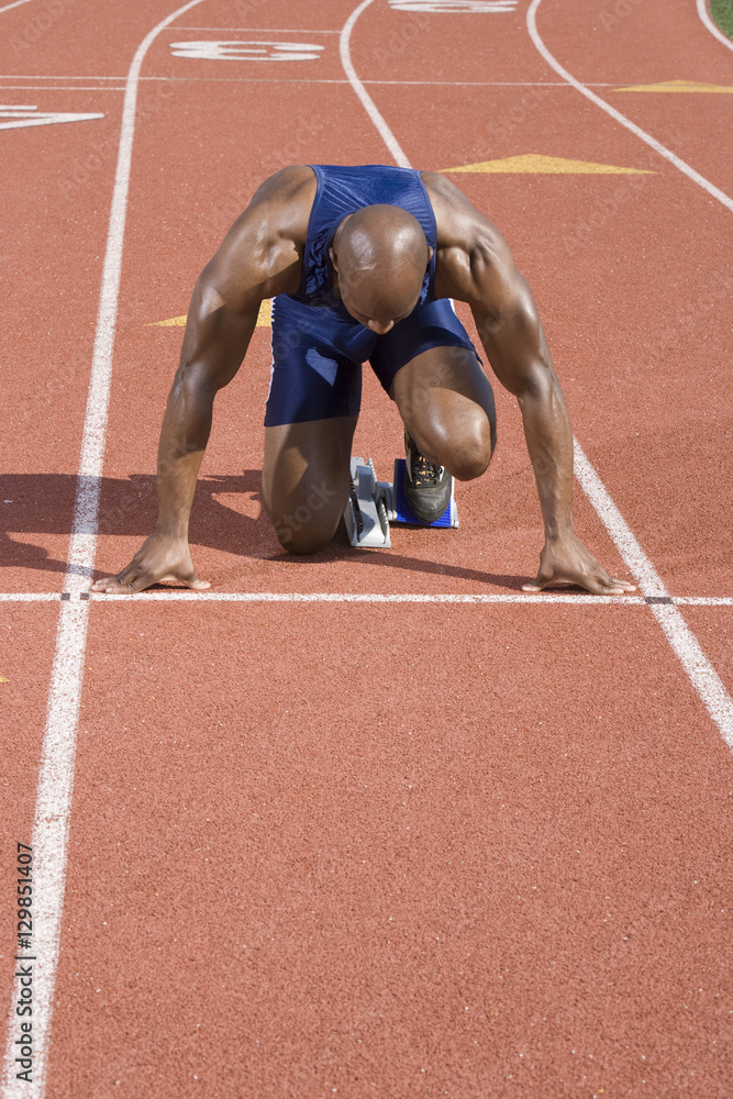 African American male sprinter in starting blocks at race track Stock ...