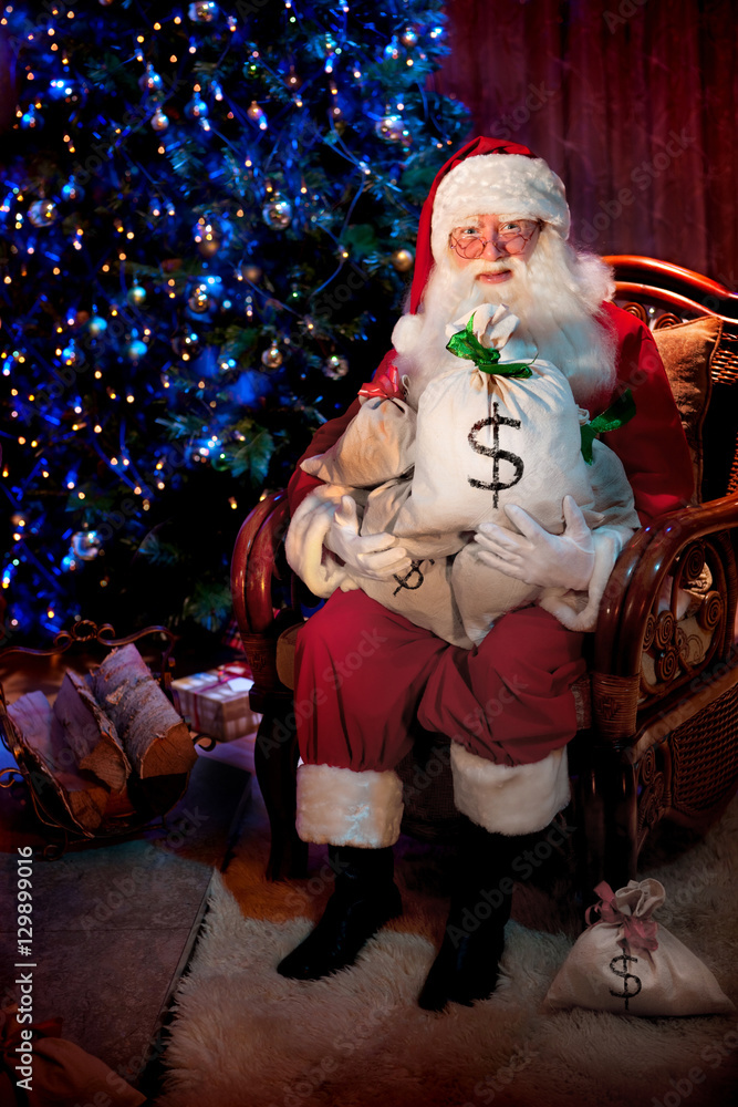 Santa Claus holding a bag of money Stock Photo | Adobe Stock