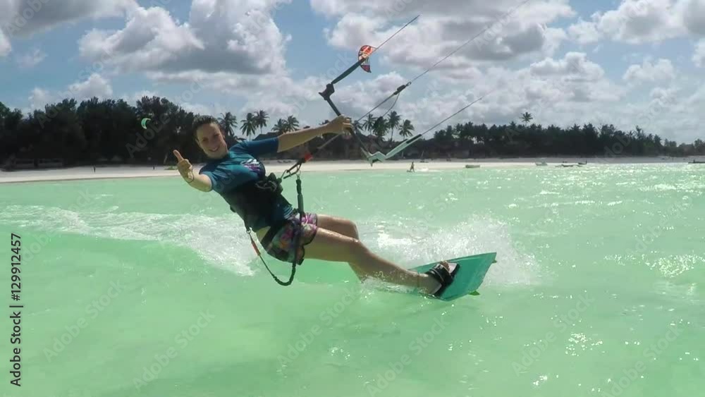 SLOW MOTION: Happy surfer girl kitesurfing in amazing blue Zanzibar ...