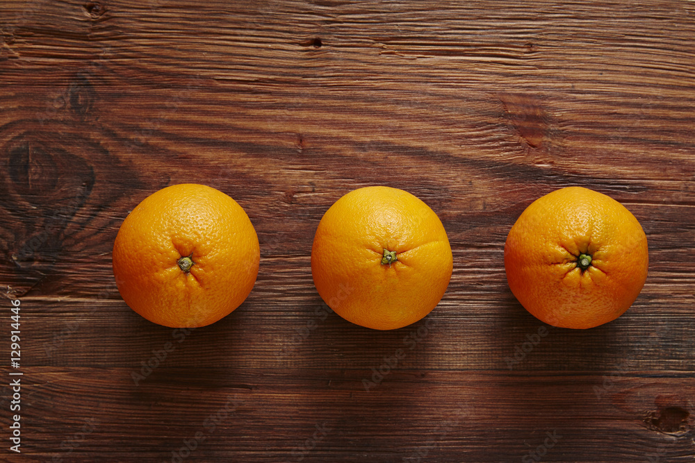 three organic oranges in a row of three Stock Photo | Adobe Stock