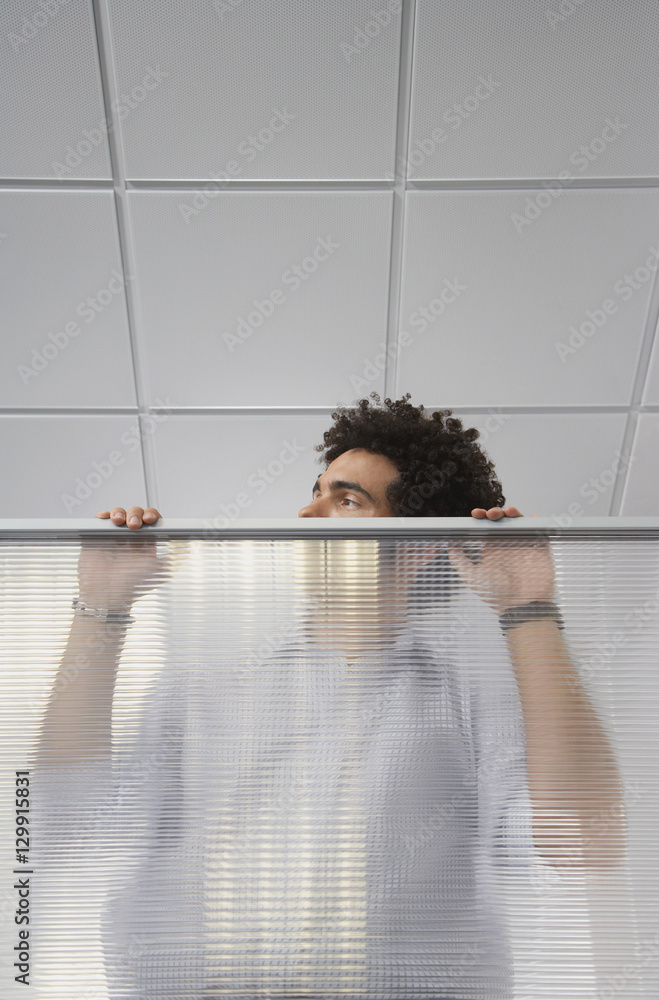 Young male office worker peering over cubicle wall in the office Stock ...