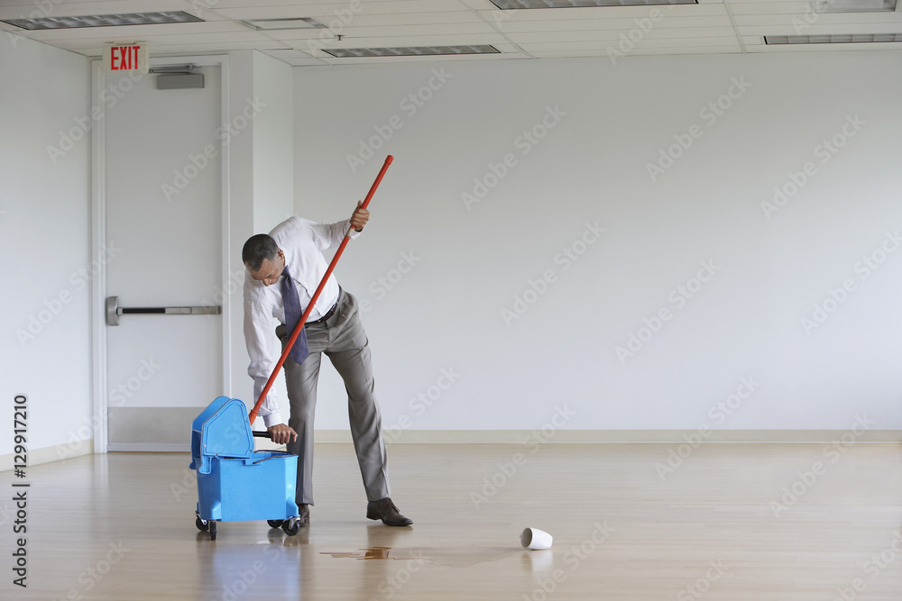 Full length of a middle aged businessman using mop in empty room Stock ...