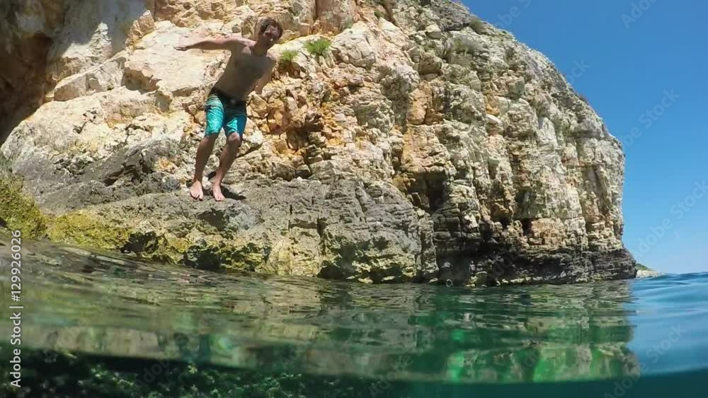 SLOW MOTION CLOSE UP: Man jumping head first into crystal clear water ...