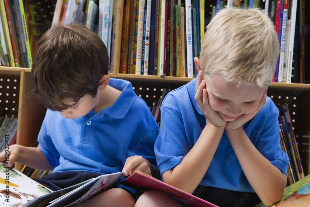 Schoolboys reading picture books in school library Stock Photo | Adobe ...