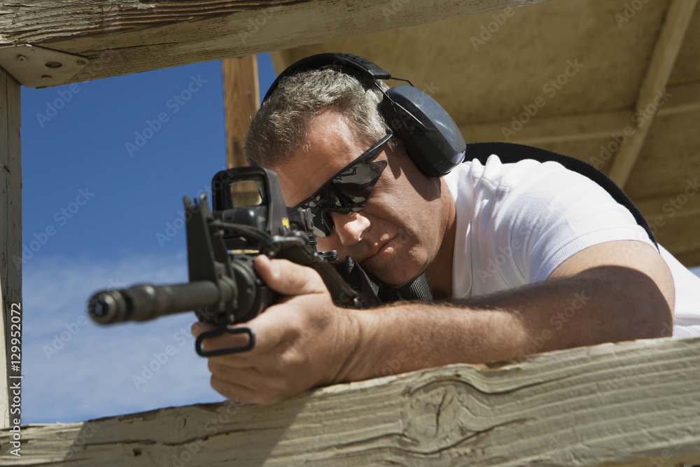 Caucasian man aiming machine gun at firing range Stock 写真 | Adobe Stock