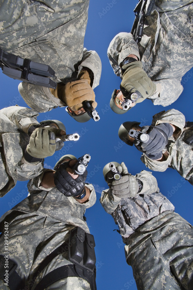 Low angle portrait of Us army soldiers standing in circle with pistols ...