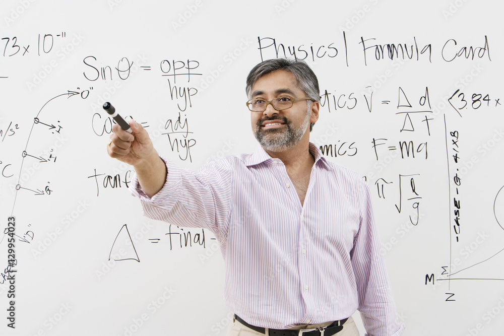 Happy lecturer asking questions while standing against white board ...