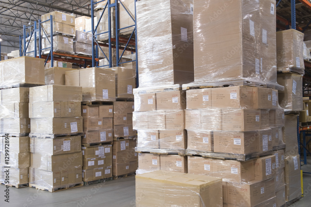 Cardboard boxes stacked in distribution warehouse Stock Photo | Adobe Stock