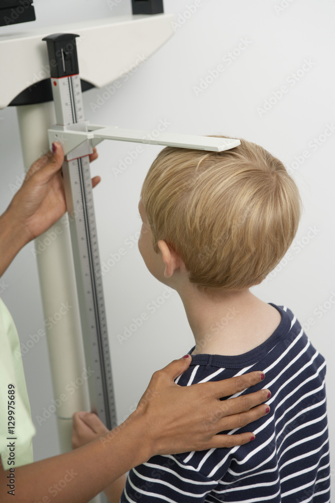 Female nurse measuring boy's height in the clinic Stock Photo | Adobe Stock