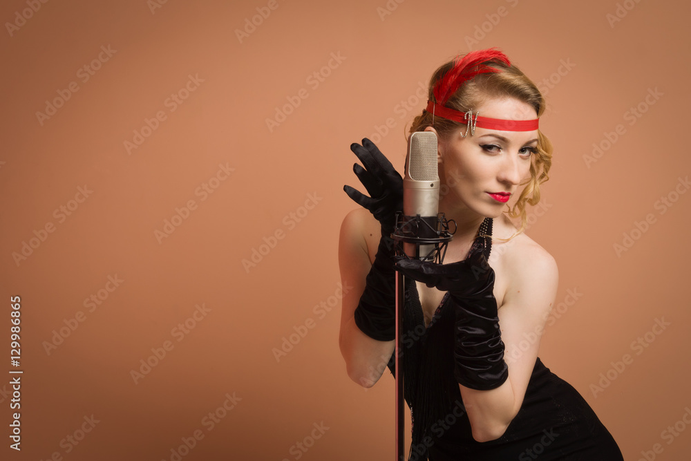 Pretty actress in black retro dress singing with microphone Stock Photo ...