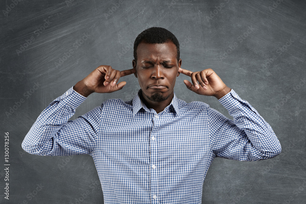 Stop this sound! Portrait of angry and frustrated African man in shirt ...