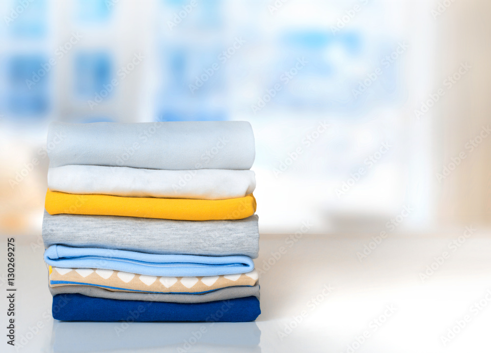 Stack cotton folded clothes on table indoors empty space. Stock Photo ...