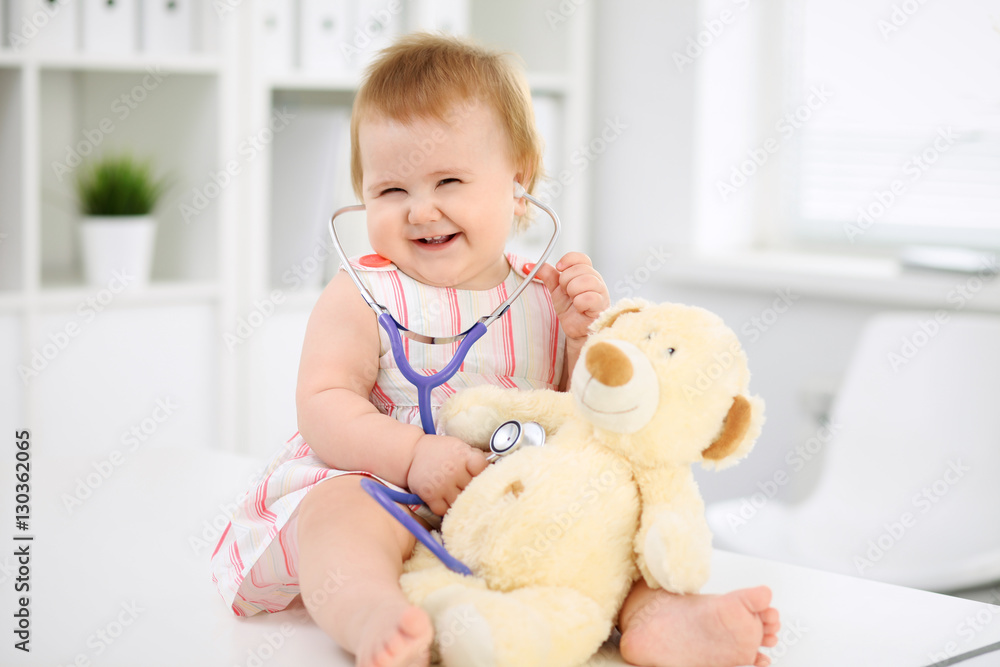 Happy cute baby after health exam at doctor's office. Medicine and ...