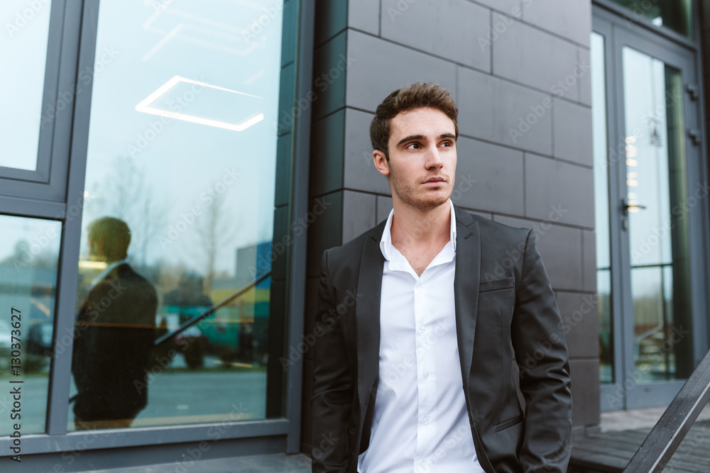 Serious business man standing near the office building Stock Photo ...