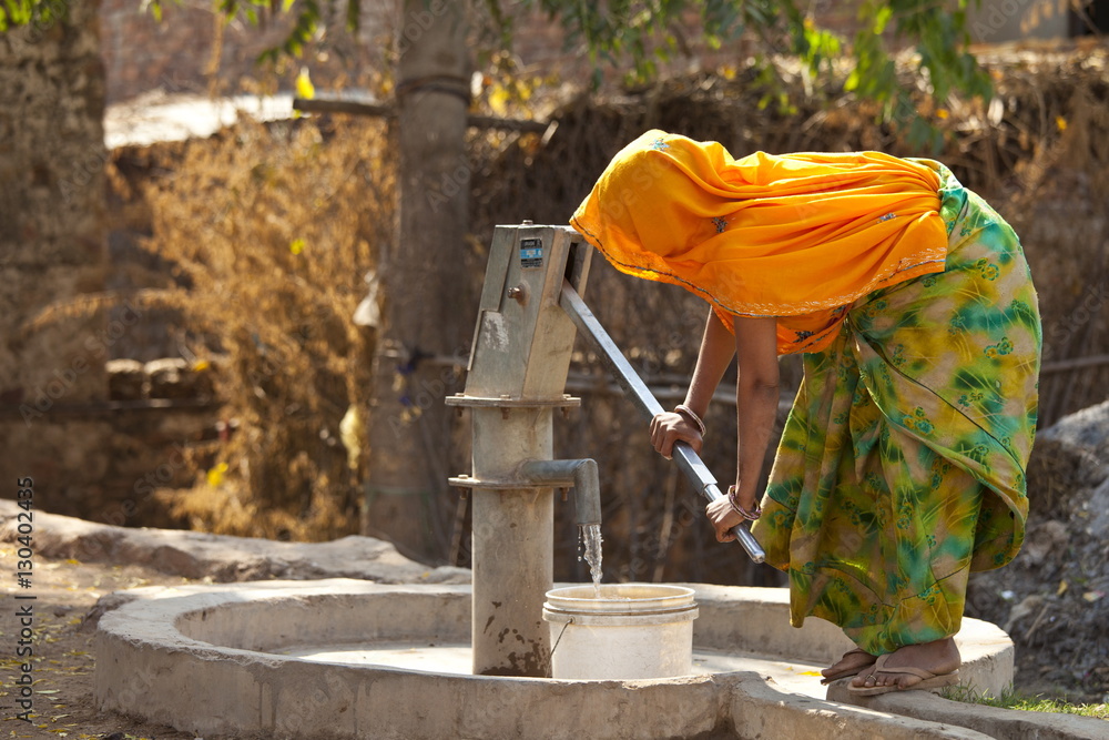 Indian woman villager pumping water from a well at Sawai Madhopur in ...