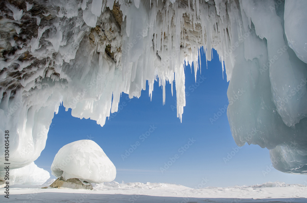 Long blue icicles in the ice cave at coastal cliffs. Unusual natural ...
