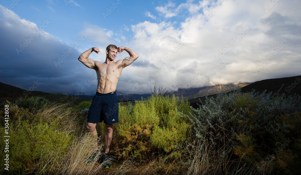 Male fitness model running allong a trail in the field, bare che Stock ...