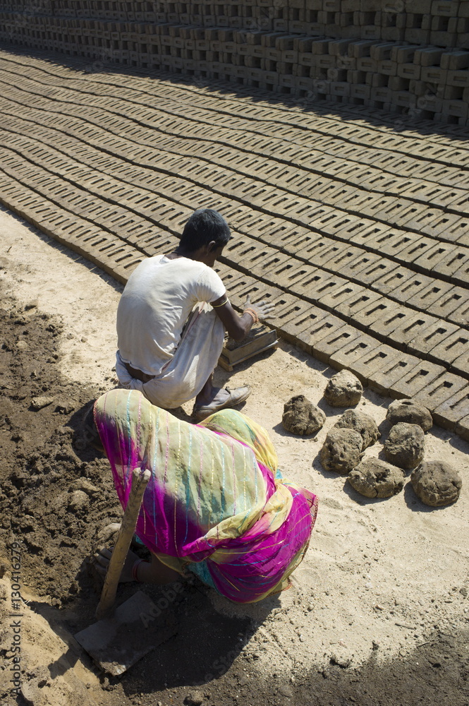 Indian family forming bricks made from mud clay at Khore Bricks Factory ...