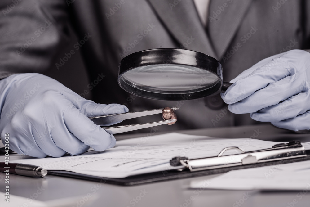 Detective through a magnifying glass looking at a evidence Stock Photo ...