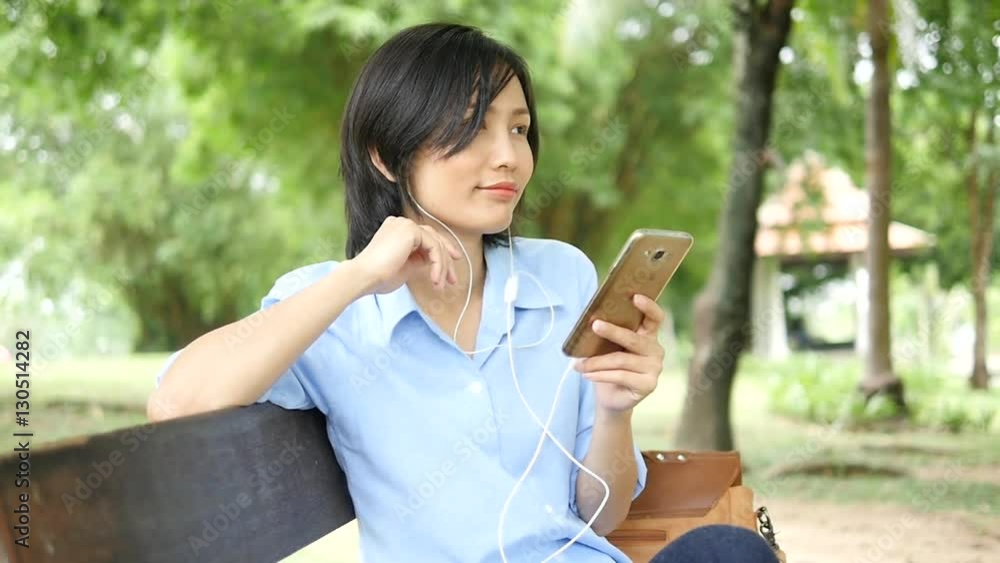 woman using smart phone and walking in the park Stock Video | Adobe Stock